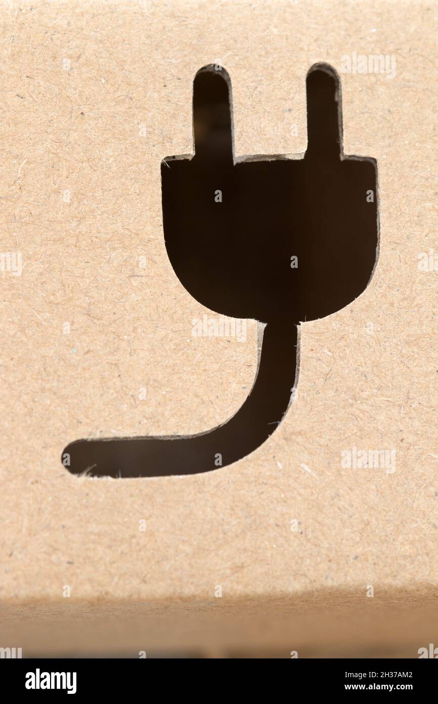 Electrical plug symbol cut out on cardboard packaging Stock Photo - Alamy