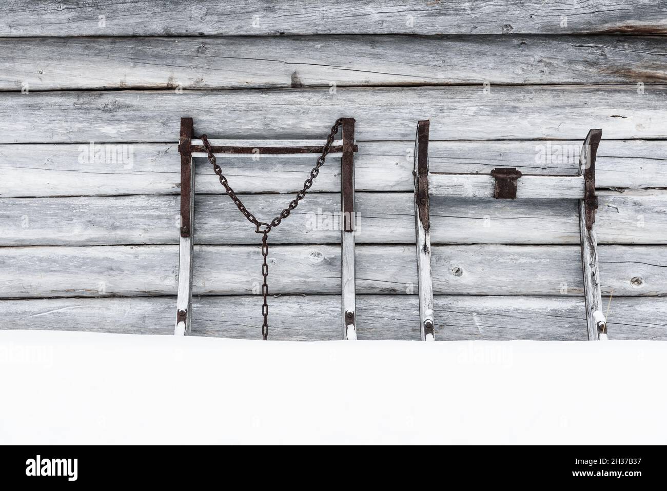 Old sled slides standing against wooden wall Stock Photo - Alamy