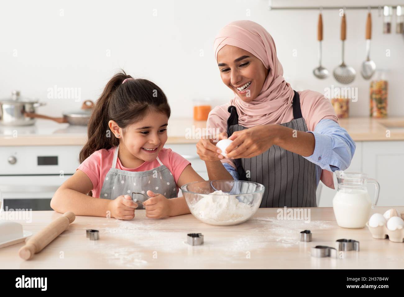 Cheerful Muslim Family Mother And Little Daughter Cooking In Kitchen ...