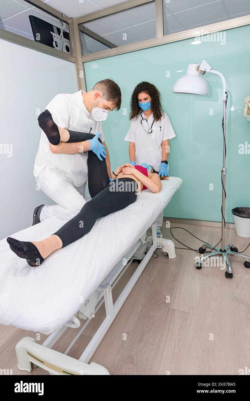 Doctor working on the hip of a young woman Stock Photo - Alamy