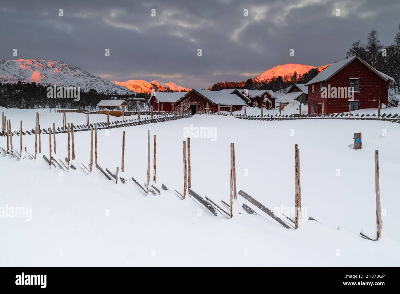 Snow covered buildings in front of first light on mountains Stock Photo ...