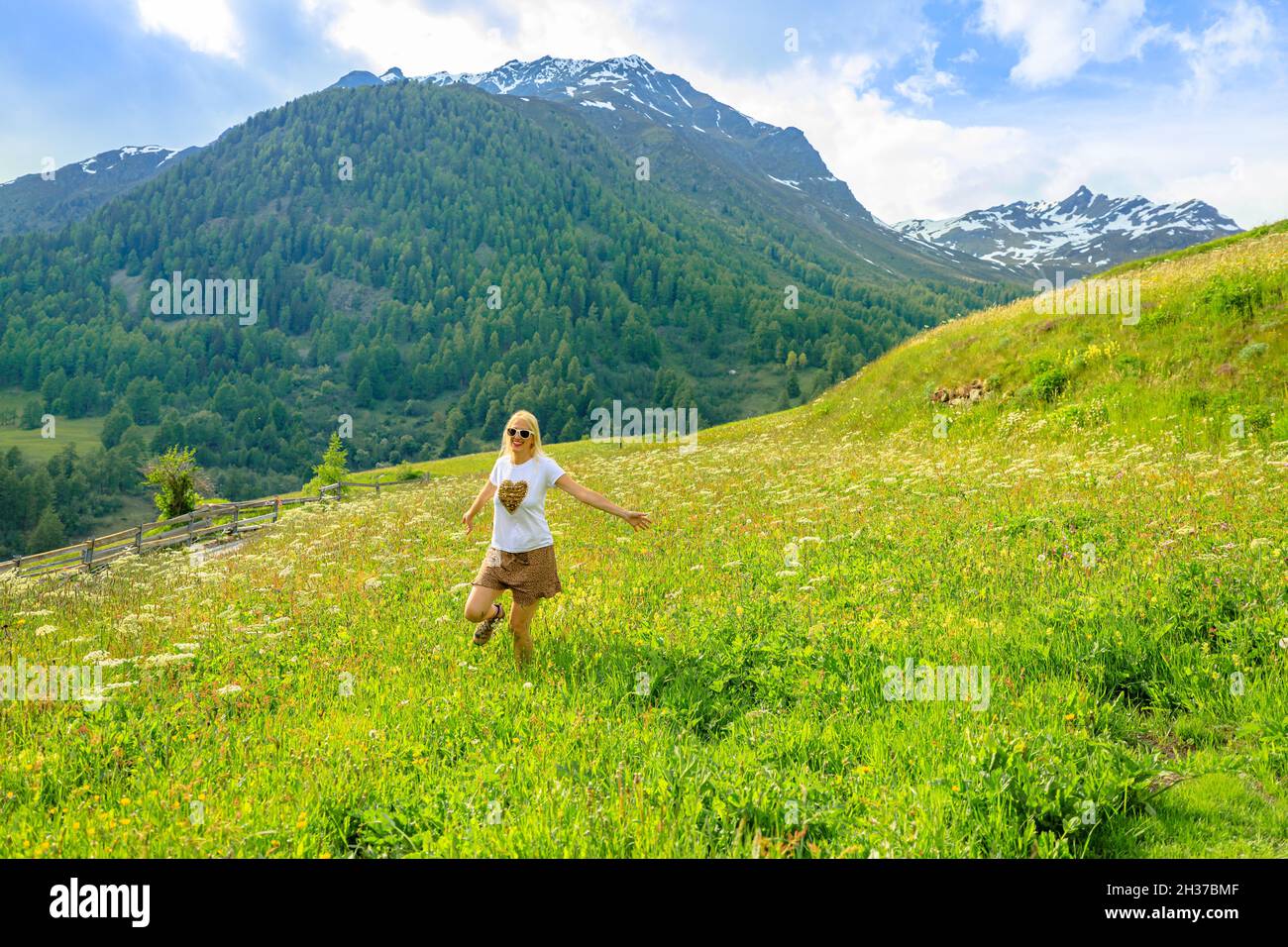happy carefree woman with a short skirt running in the countryside of ...