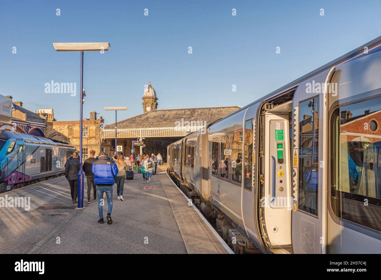 Carriages of a train stand next to a platform of a railway station ...