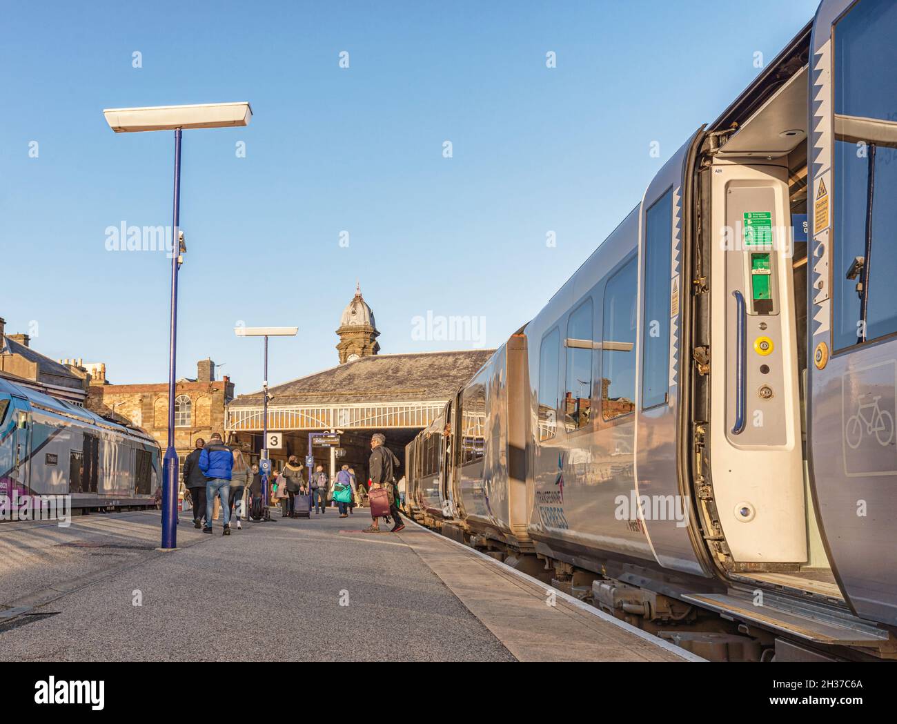 Carriages of a train stand next to a platform of a railway station ...