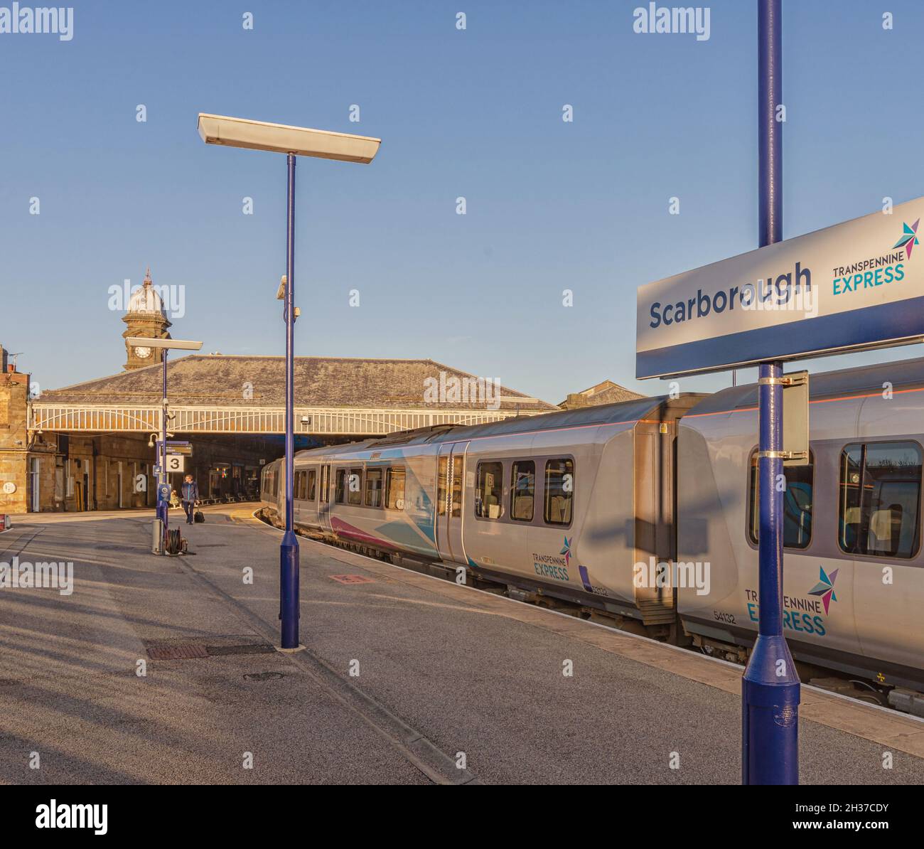 Carriages of a train stand next to a railway platform. The station ...