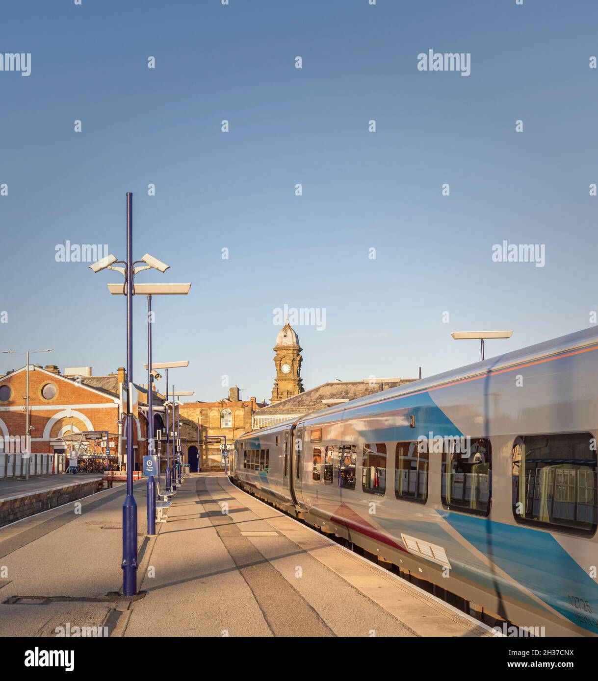 Carriages of a train stand next to a railway platform. The station ...