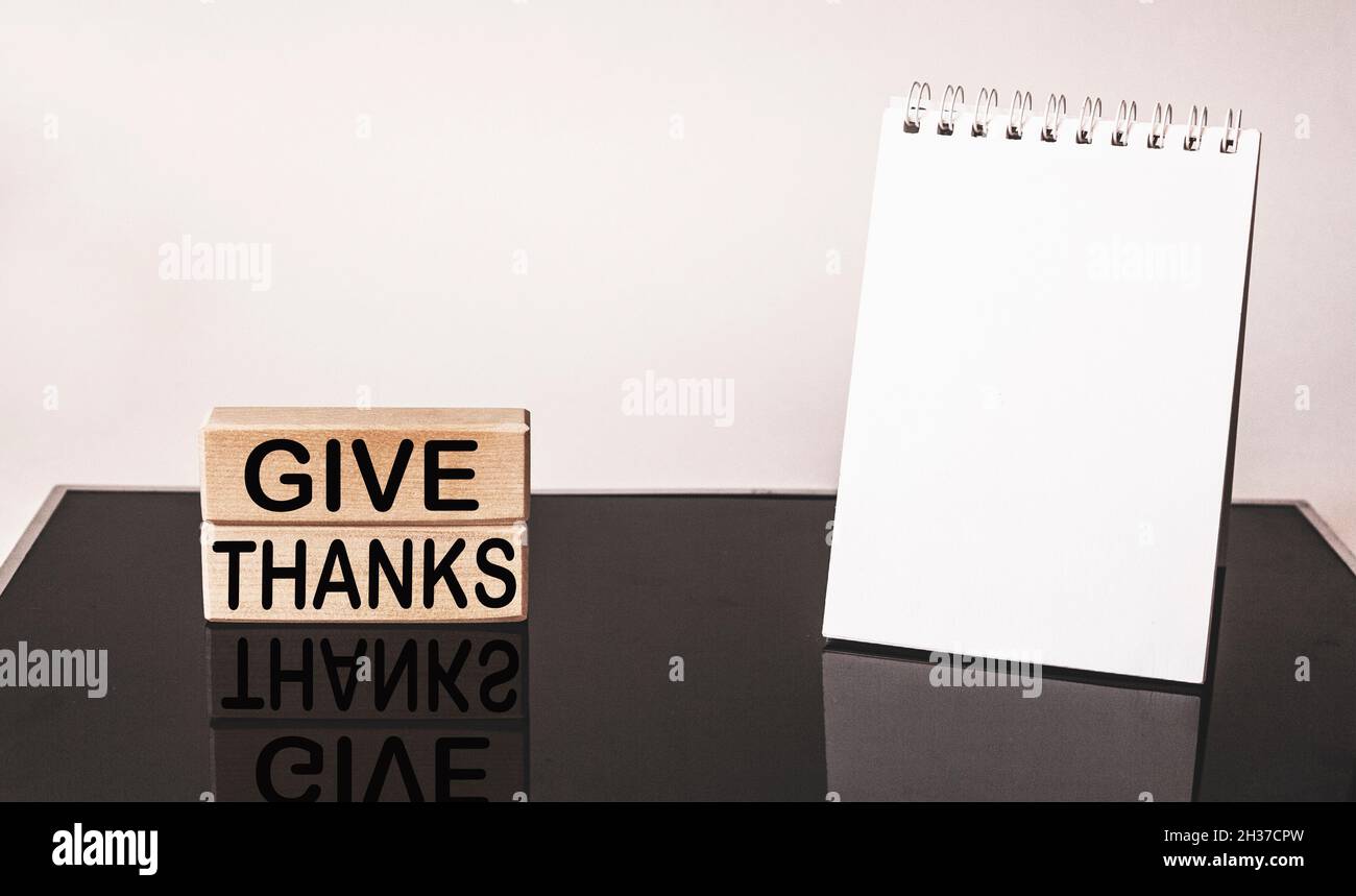 give thanks - text on wooden blocks with reflection on black mirrored ...