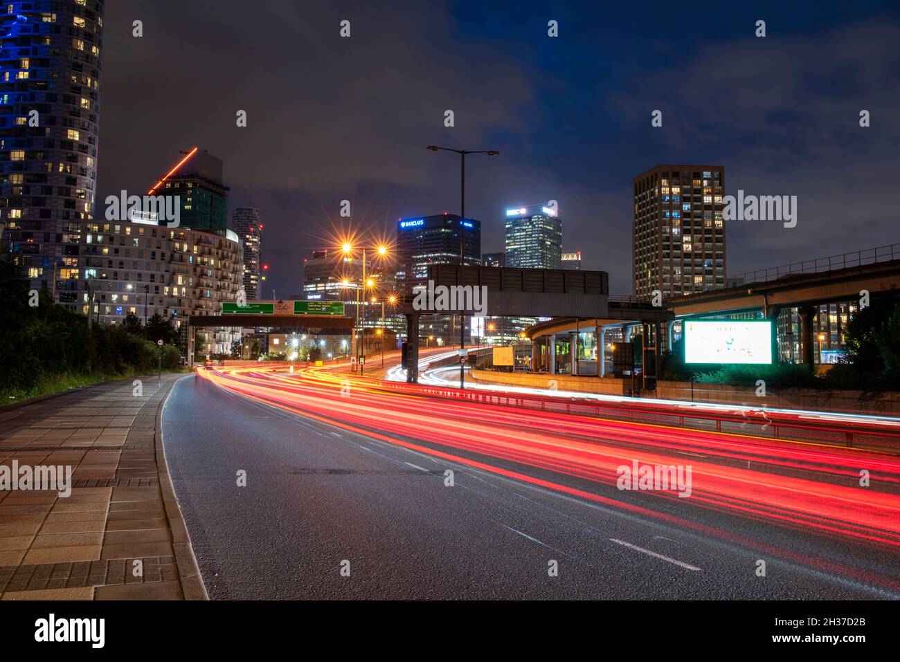 Traffic light trails on Aspen Way looking towards Canary Wharf, London ...