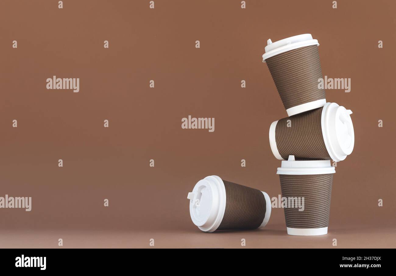 Stack of disposable brown paper coffee cups with caps Stock Photo - Alamy