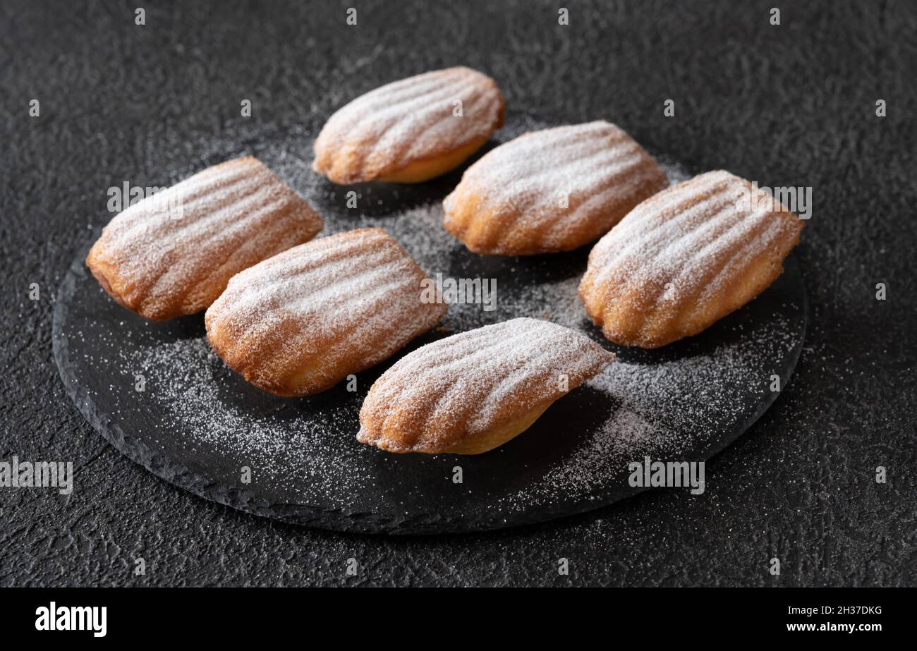 Madeleines - French small sponge cakes on the stone board Stock Photo ...