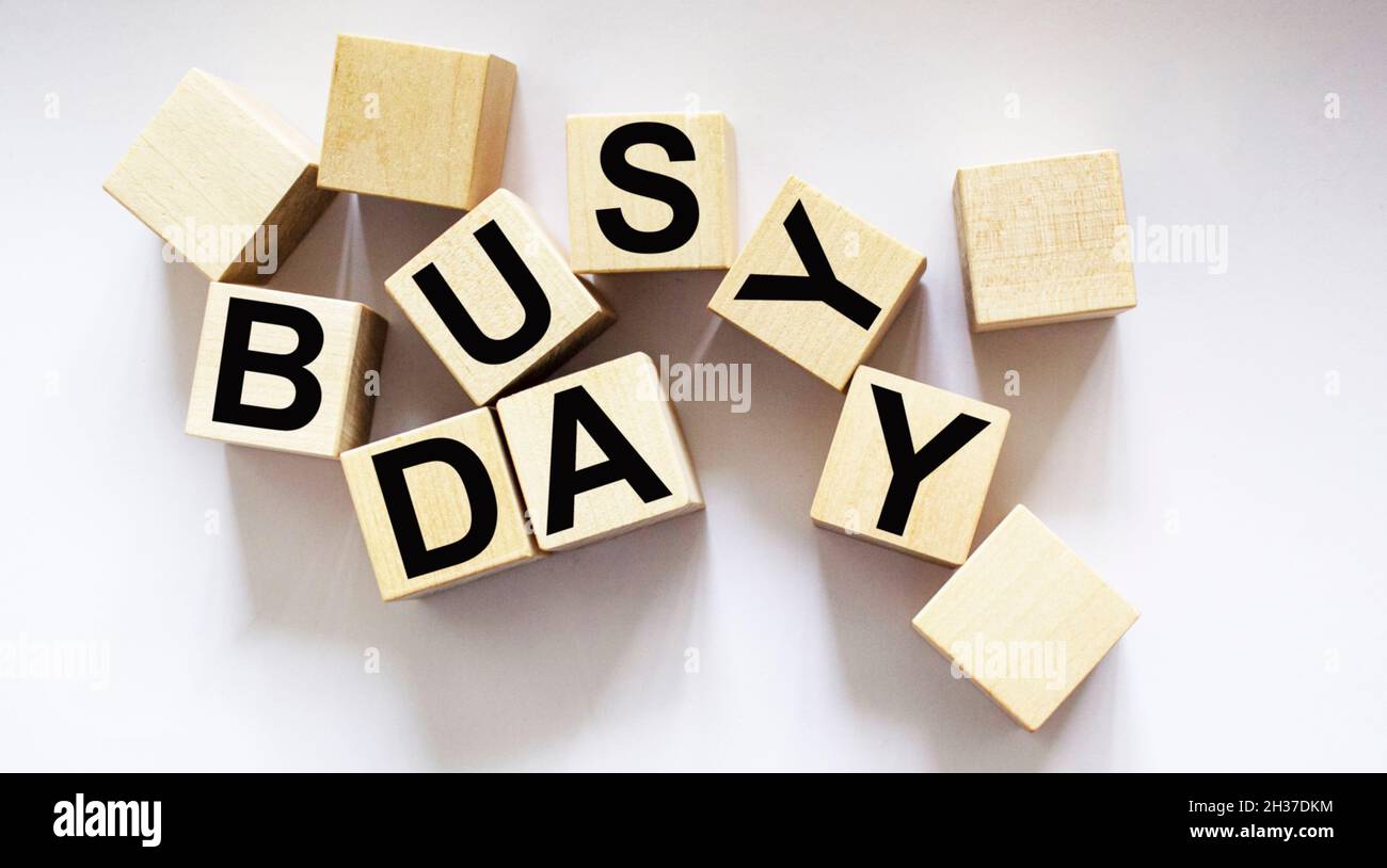 Busy day written on wooden cubes and white background Stock Photo - Alamy
