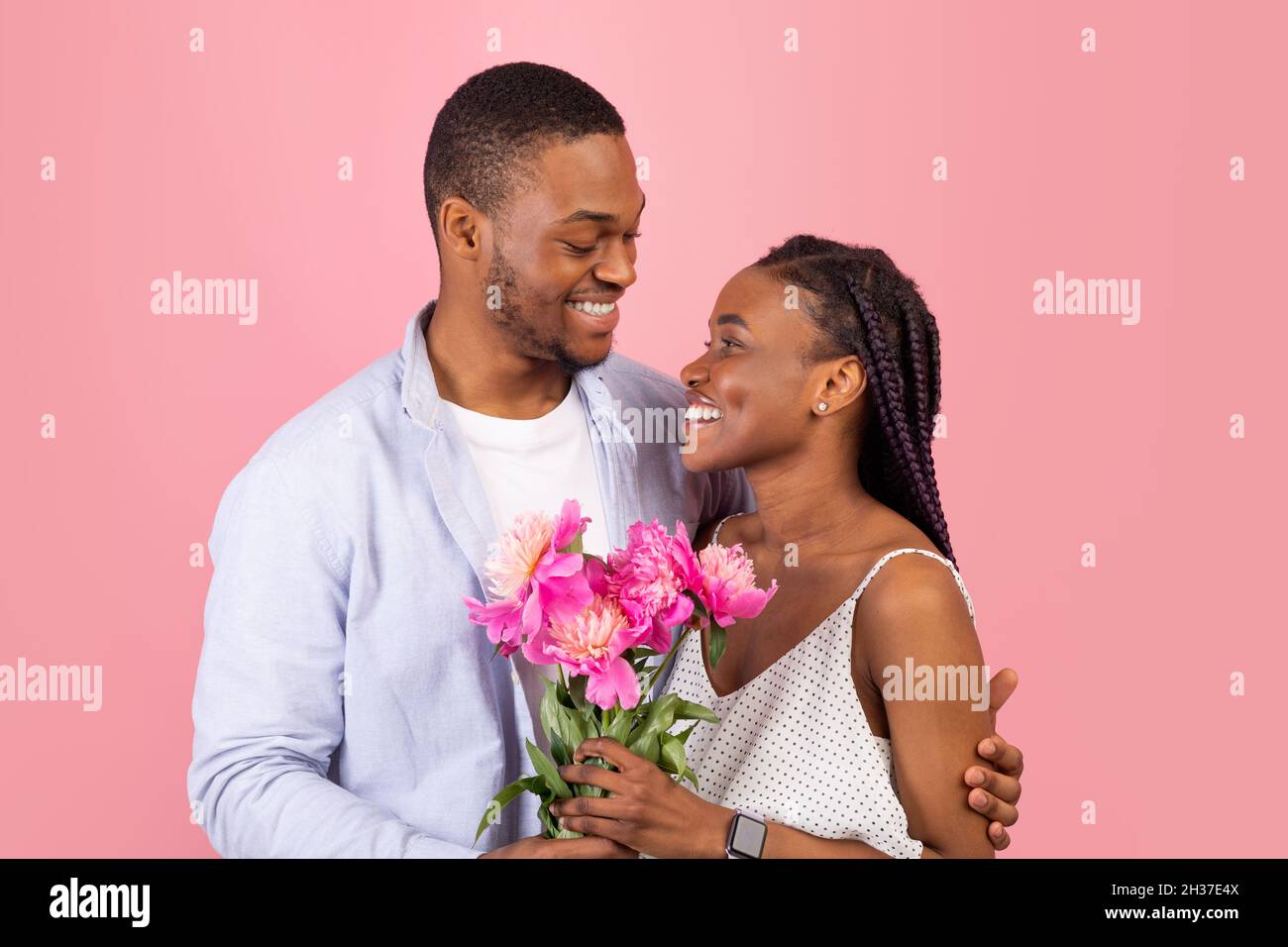 Happy black man making surprise for woman giving flowers Stock Photo ...