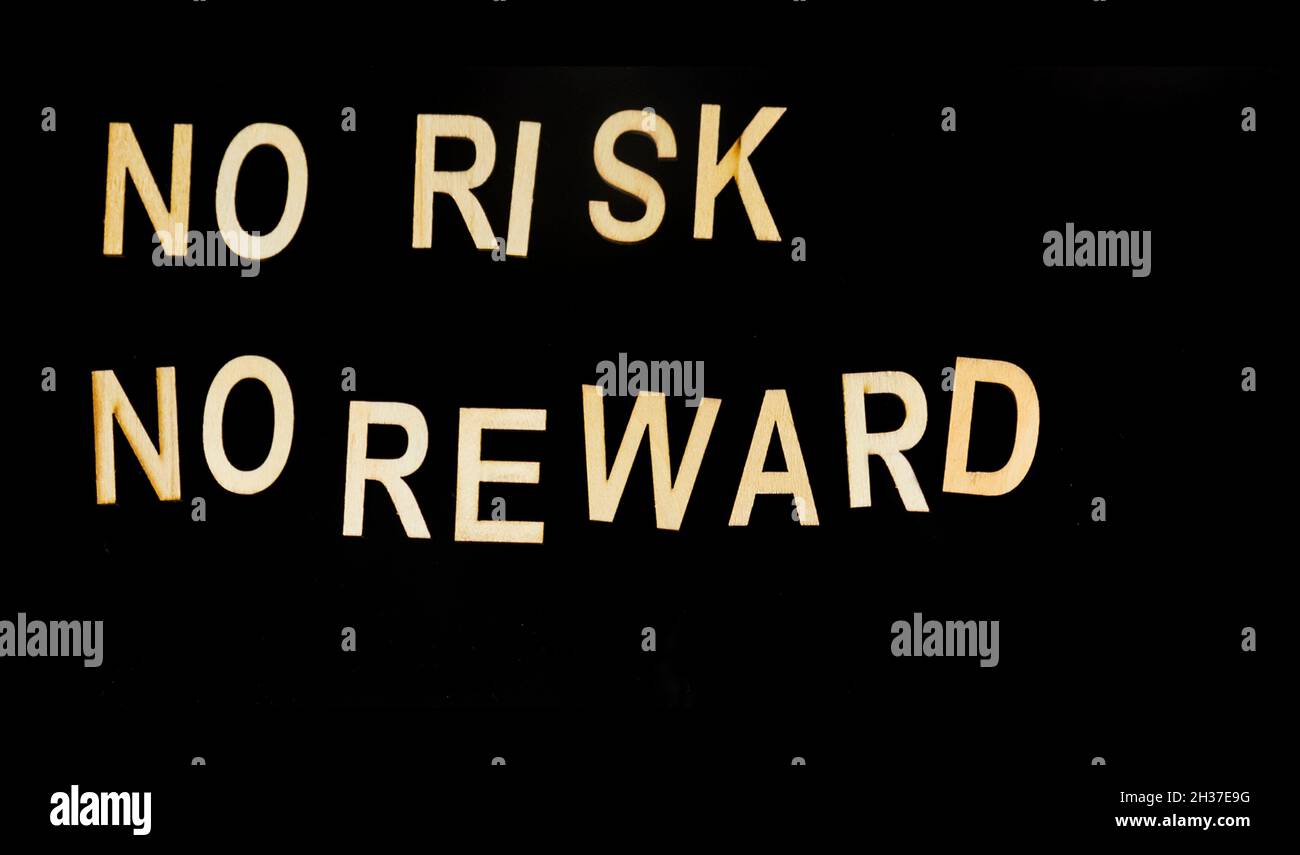On a black background, wooden letters with the text: No risk, no reward ...