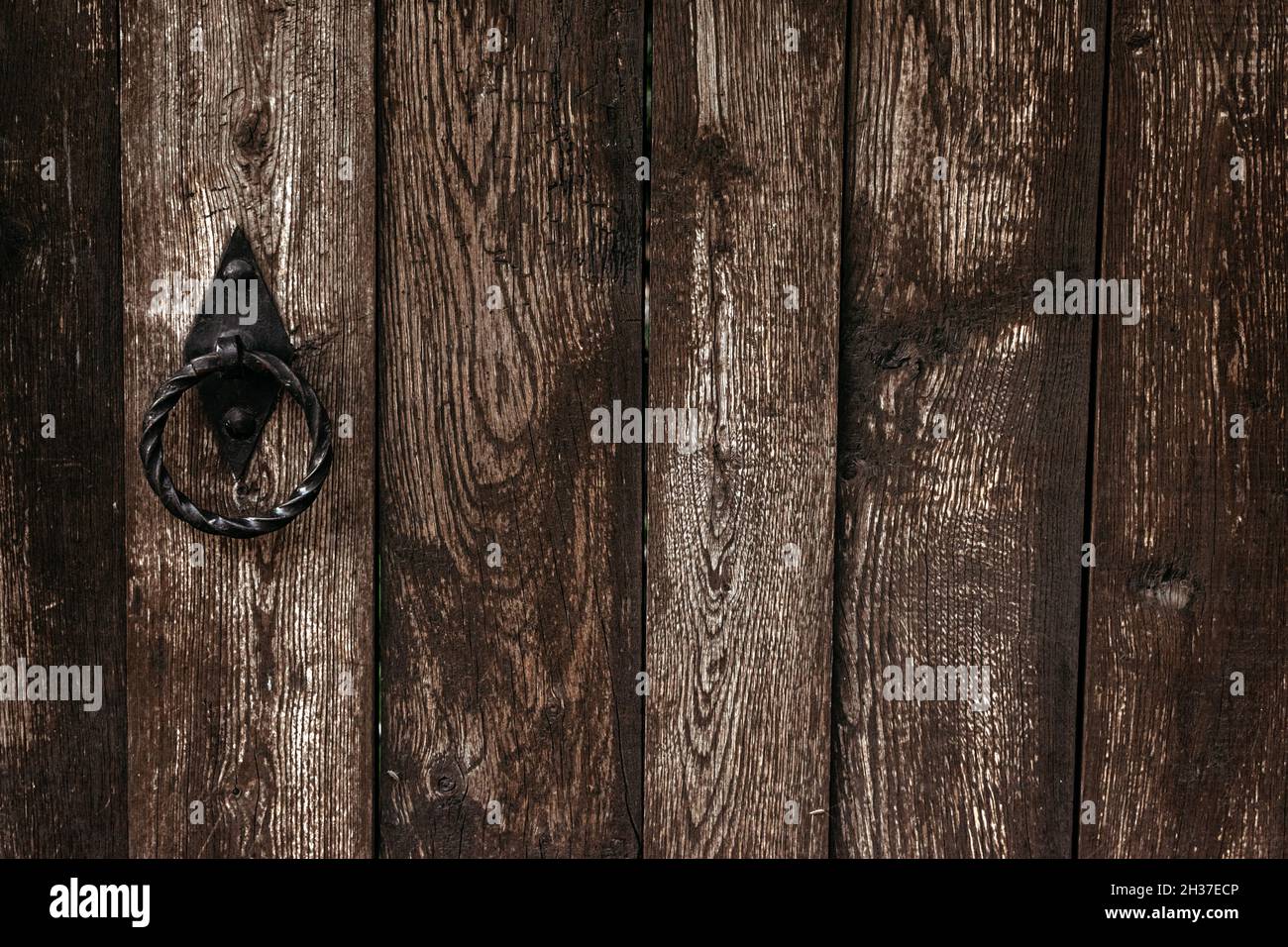 Old vintage textured wood door with ring door lock. Old brown wooden ...