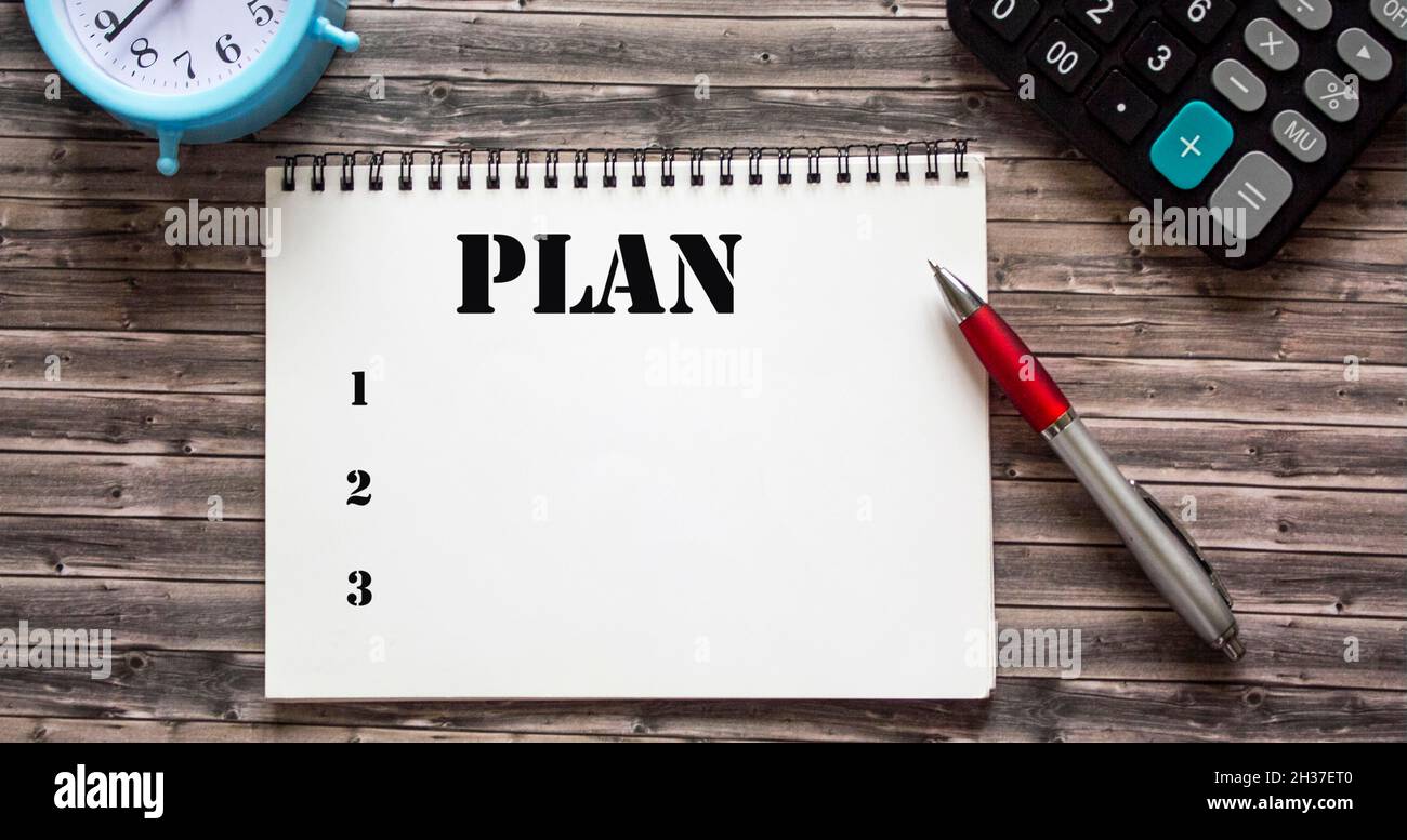 action plan text on notebook with stationery on wooden table with alarm ...