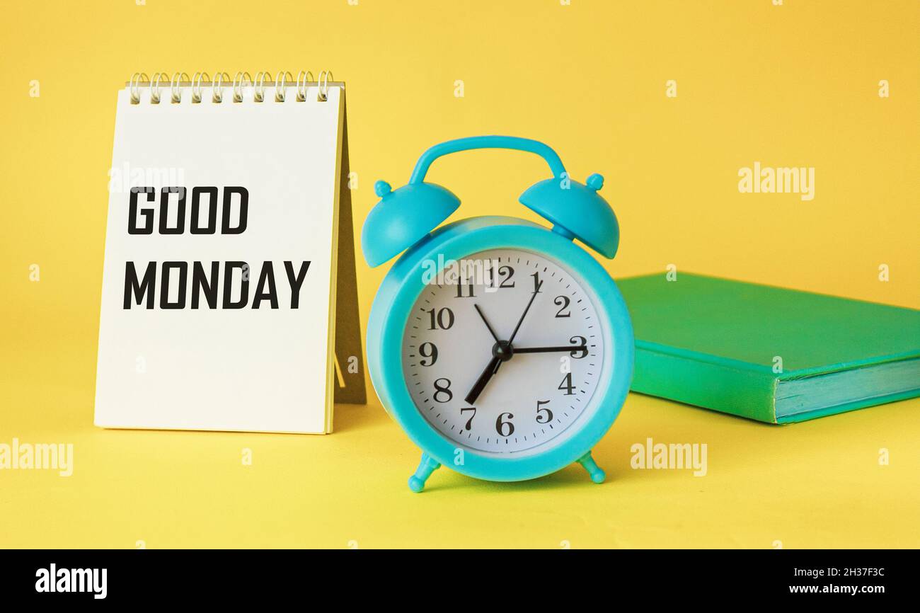 Good Monday, the text is written on a notebook, next to a clock and a ...