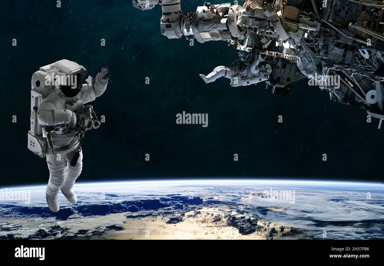 Astronaut and space station orbiting planet Earth. Solar system Stock ...