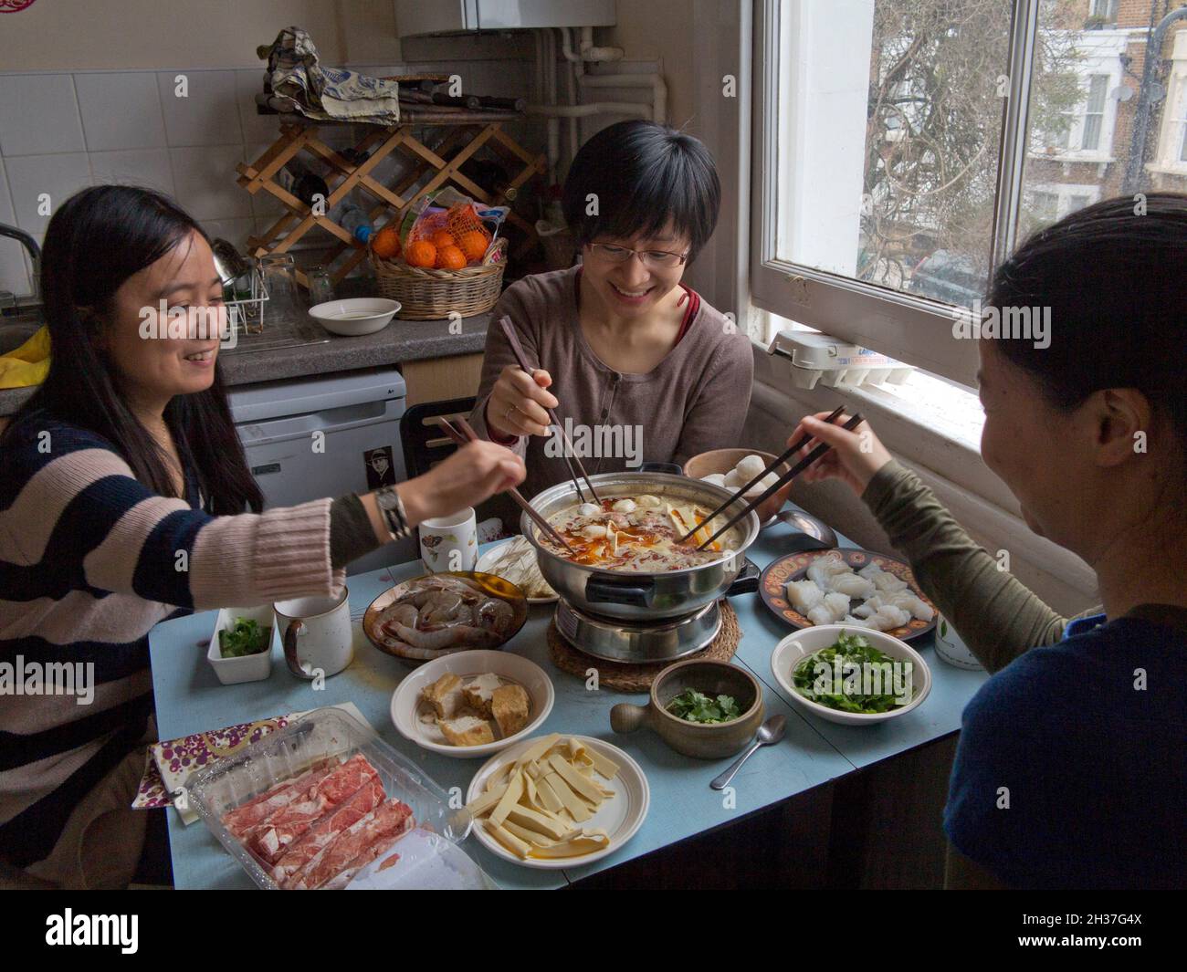 Chinese women eating traditional hot pot at home in Birmingham,England ...