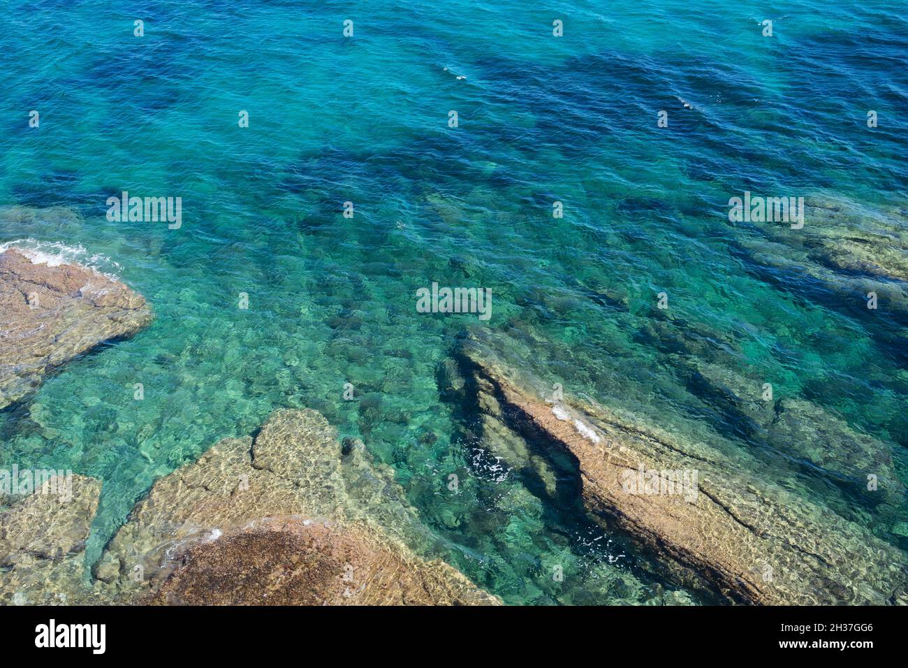 clear turquoise blue water texture and rocks on the Mediterranean coast ...