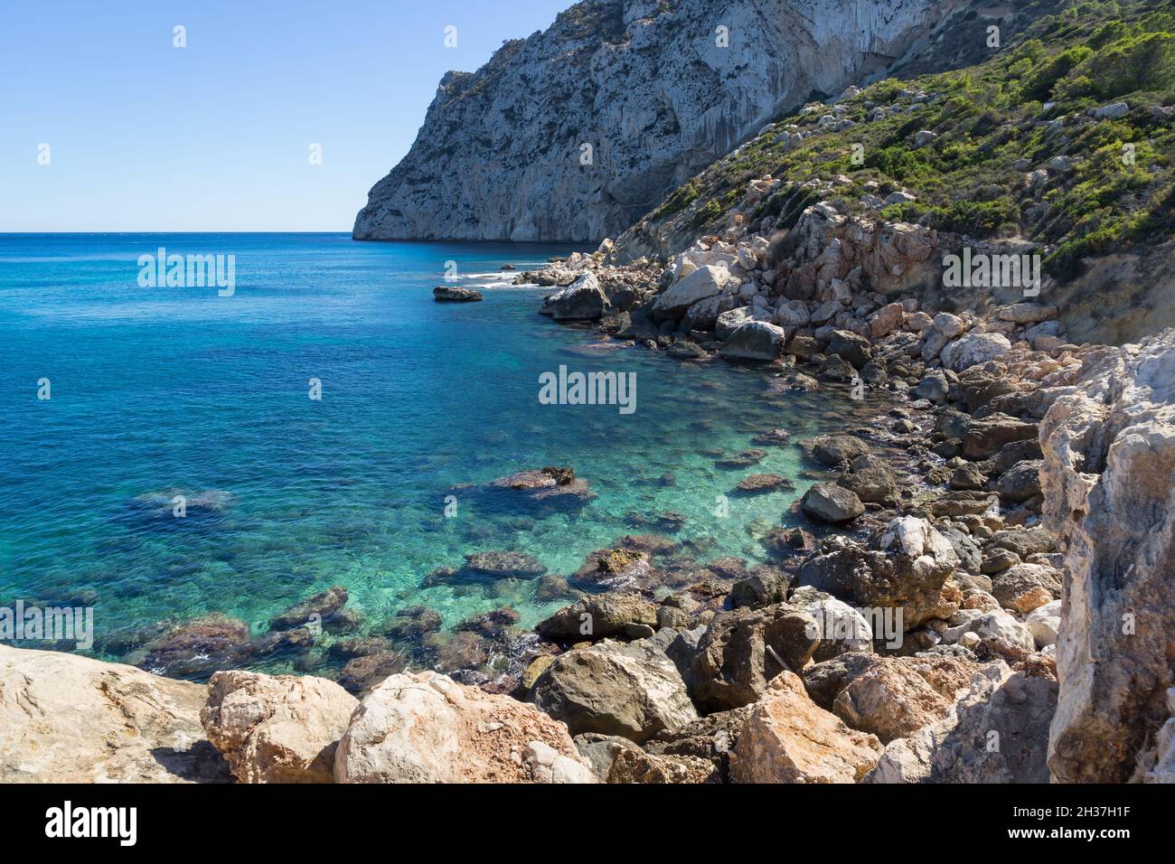 clear turquoise blue water and rocks in a beautiful bay on the ...