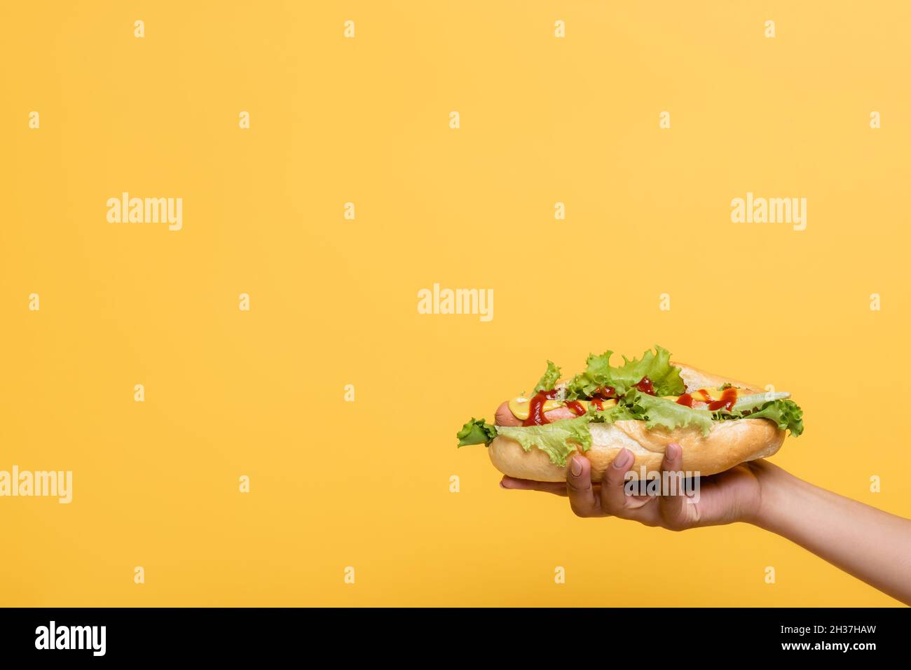 cropped view of african american woman with delicious hot dog isolated ...