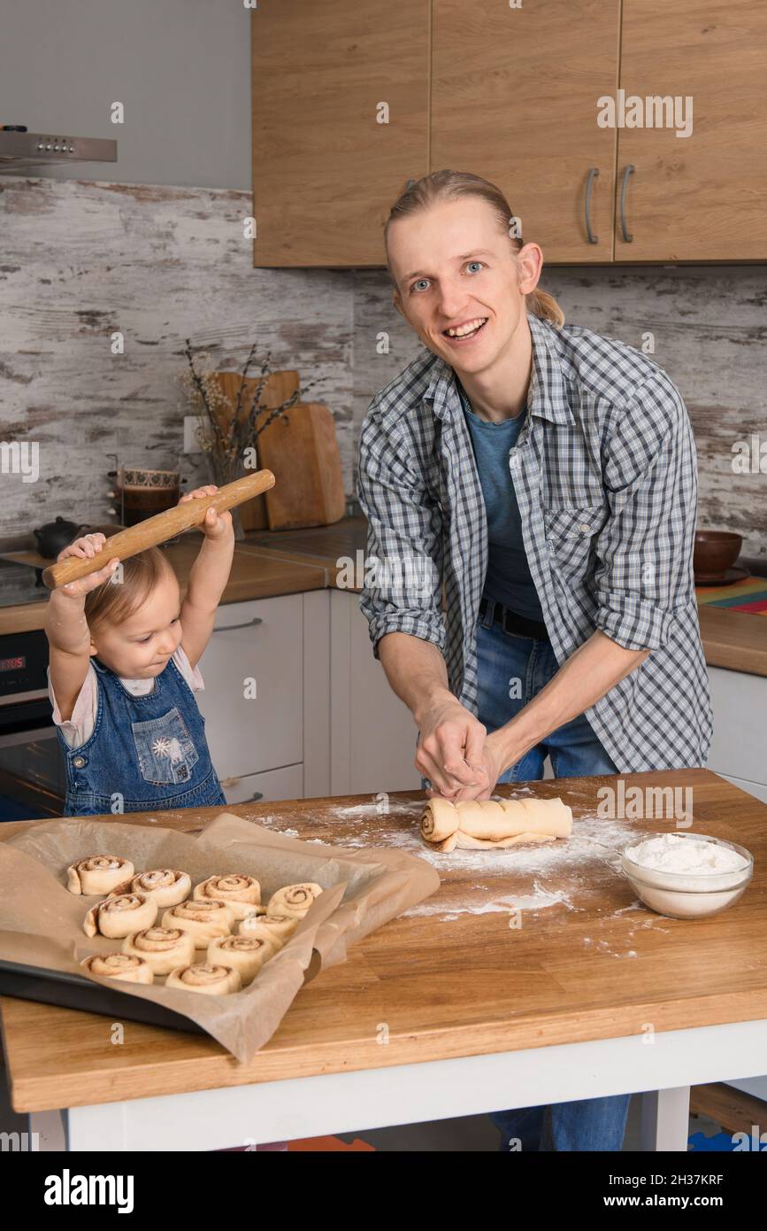 Father and child cooking on the kitchen with fun. Family baking ...