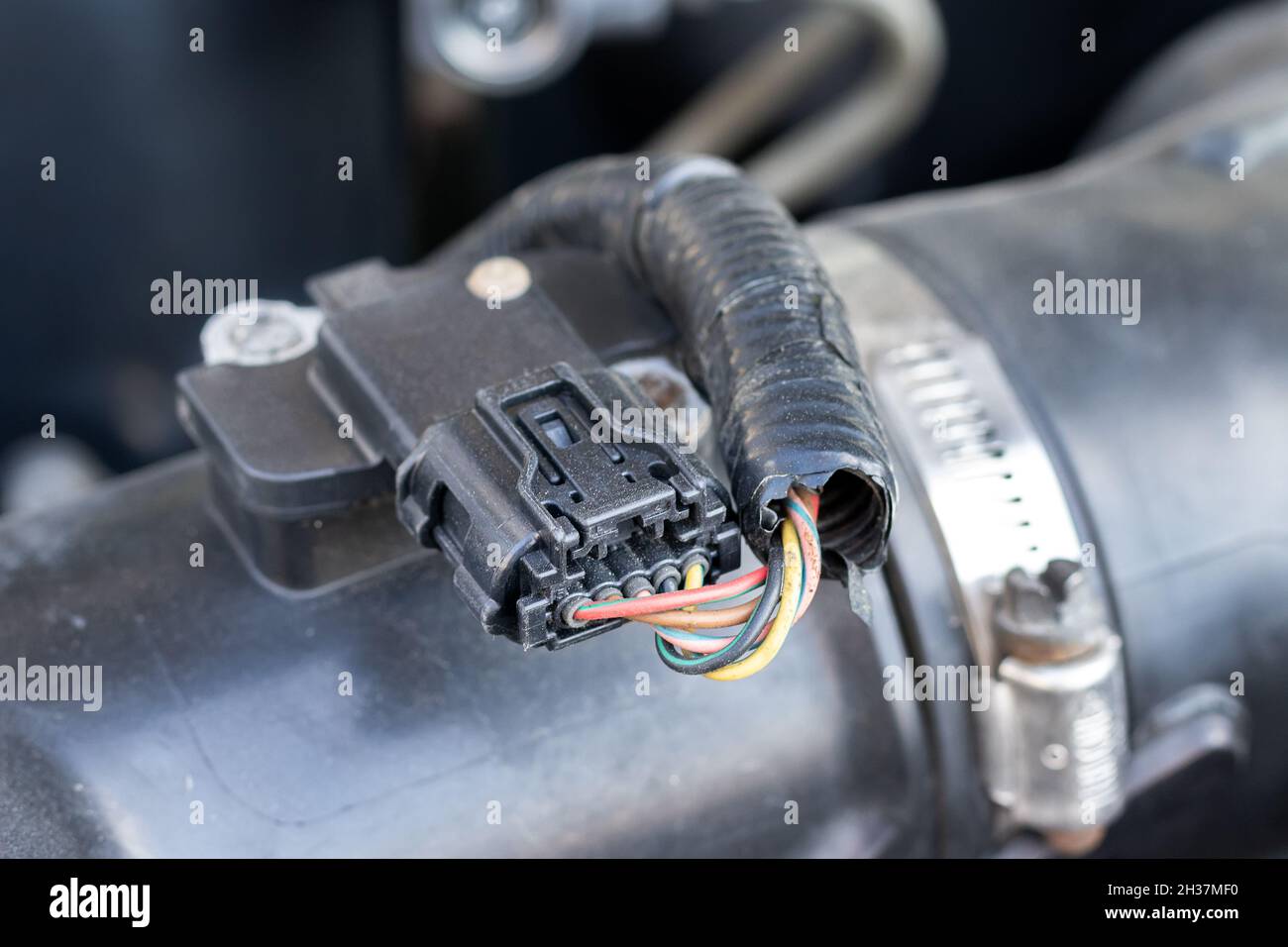 Mass air flow (MAF) sensor under the open hood of a car - measures the ...