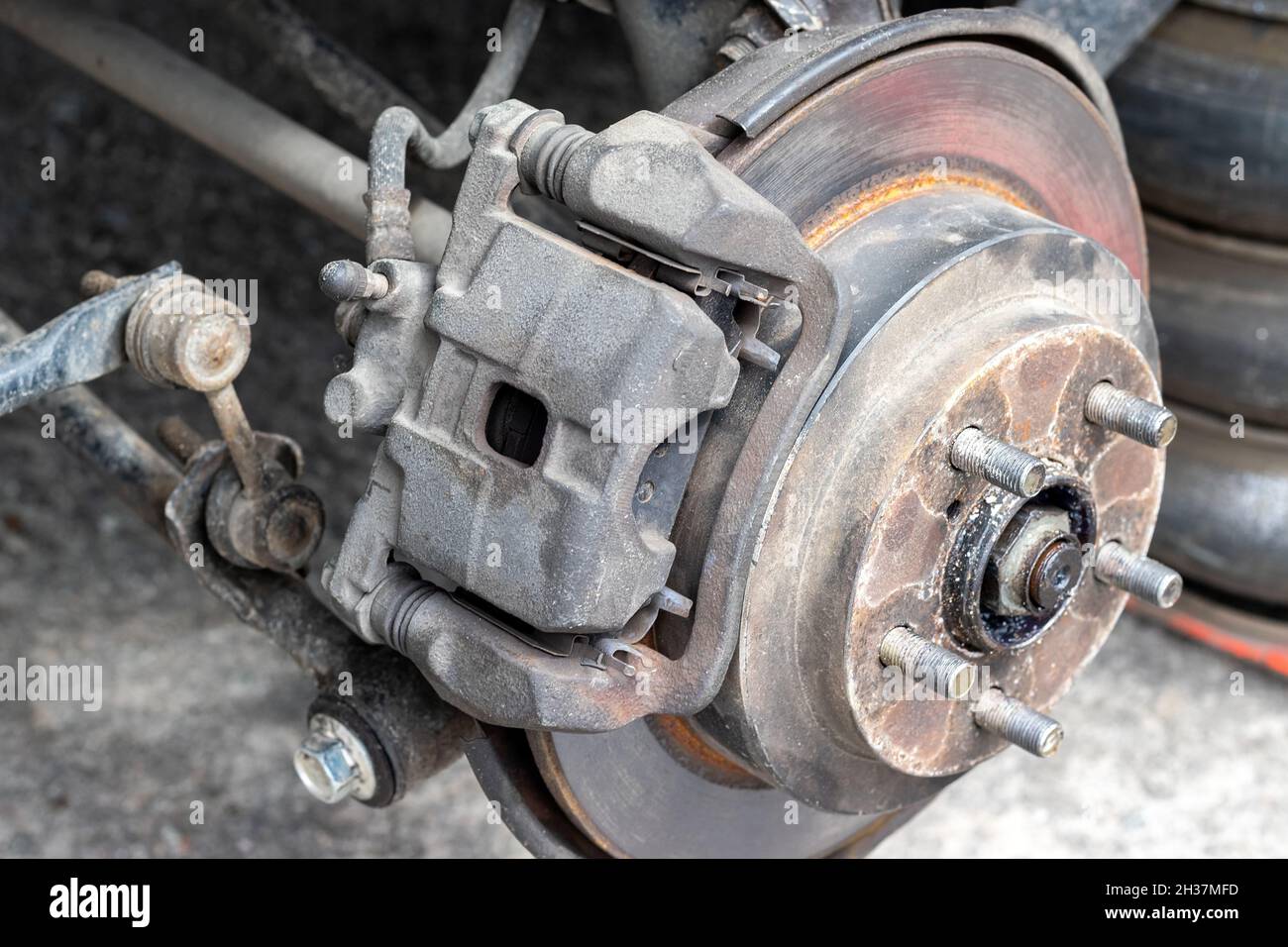 Rusty back car wheel hub with brake disc at tire shop. Car without a ...