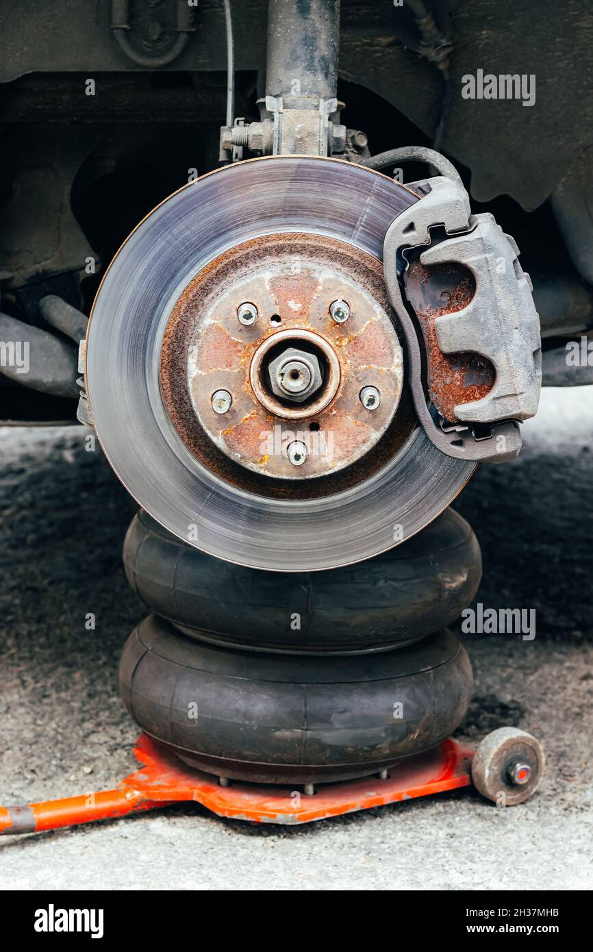 Rusty back car wheel hub with brake disc at tire shop. Car without ...