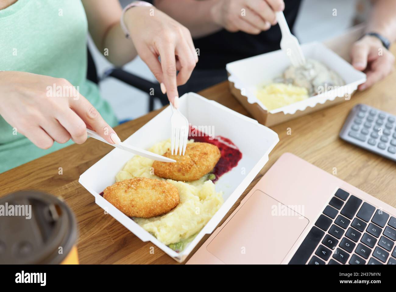 Staff eating cutlets with mashed potatoes from cardboard boxes in ...