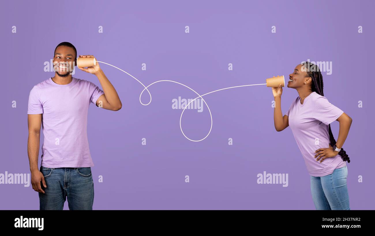 African American couple talking through tin can telephone Stock Photo ...