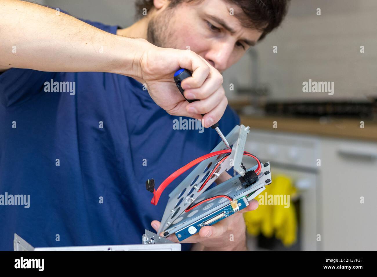 Young man assembles electronic computer components with his own hands ...