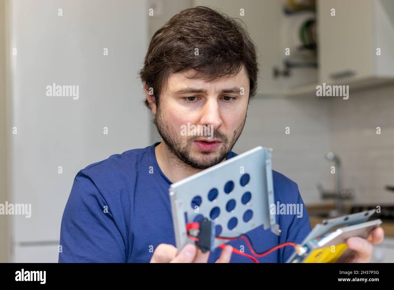 Young man assembles electronic computer components with his own hands ...