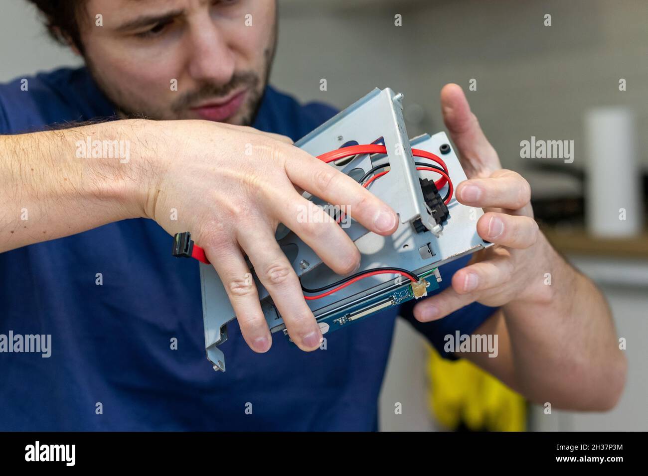 Young man assembles electronic computer components with his own hands ...