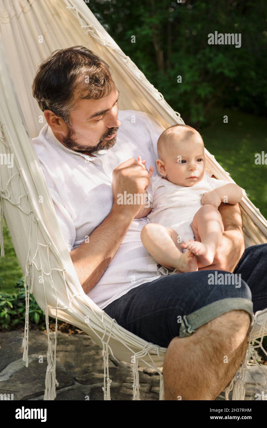Father with baby boy in hammock filling nice and tender, fatherhood ...