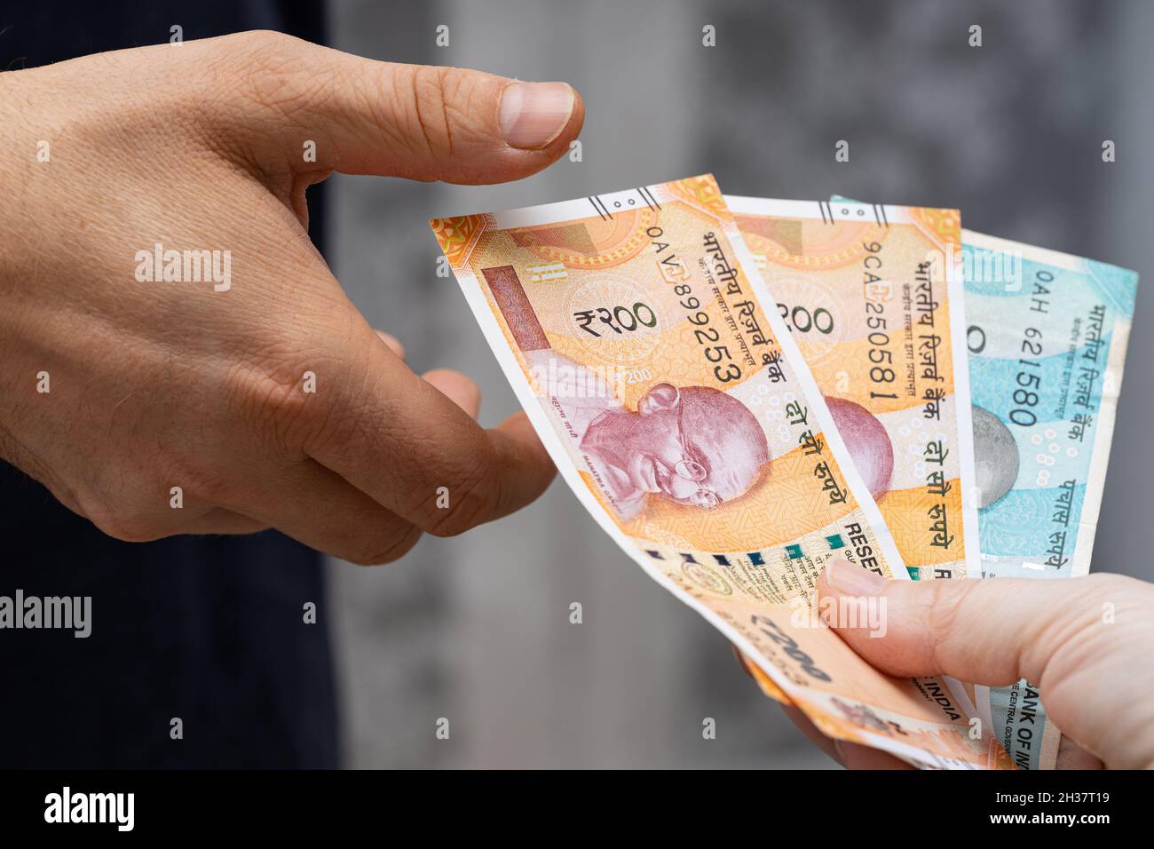 Indian money, New rupees, handed over from hand to hand Stock Photo - Alamy