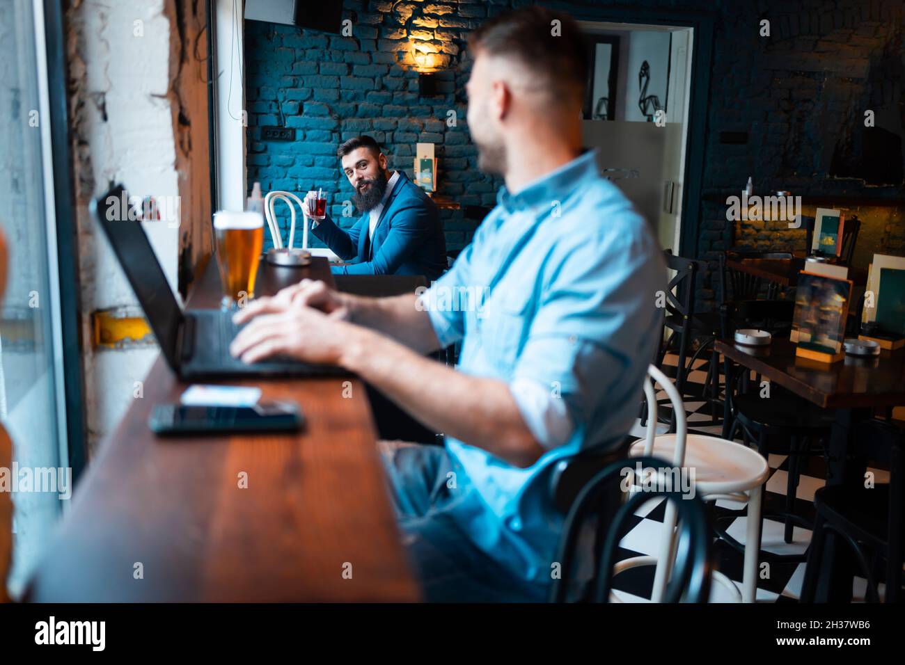 Two male friends talking in a bar Stock Photo - Alamy