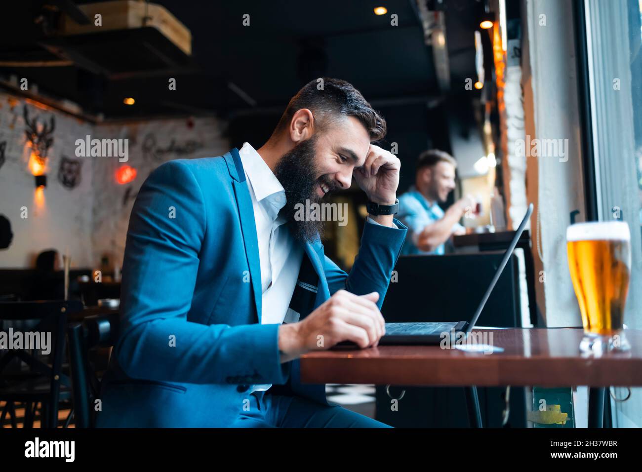 A businessman using his laptop in a pub Stock Photo - Alamy