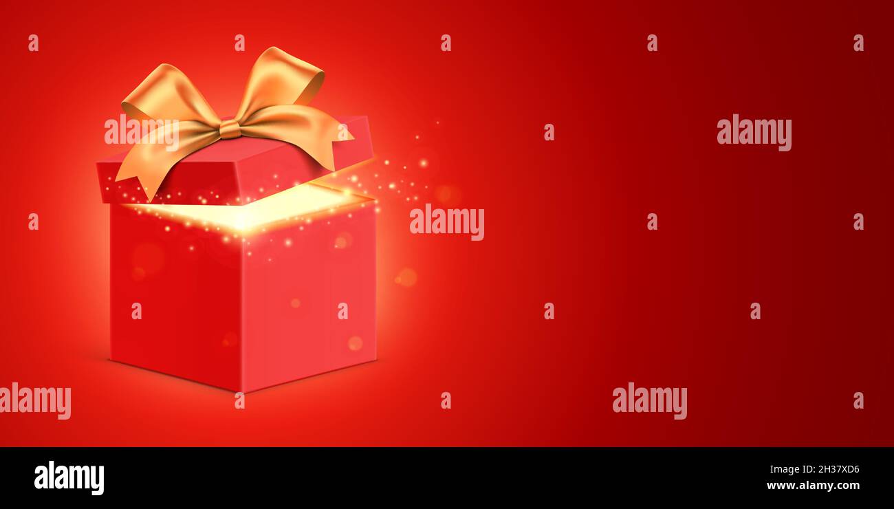 Open red gift box with a golden ribbon and magical glitter light ...
