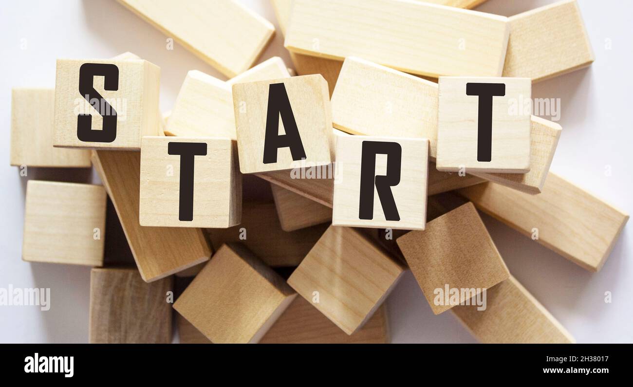 The word START written on wooden blocks against a white background ...