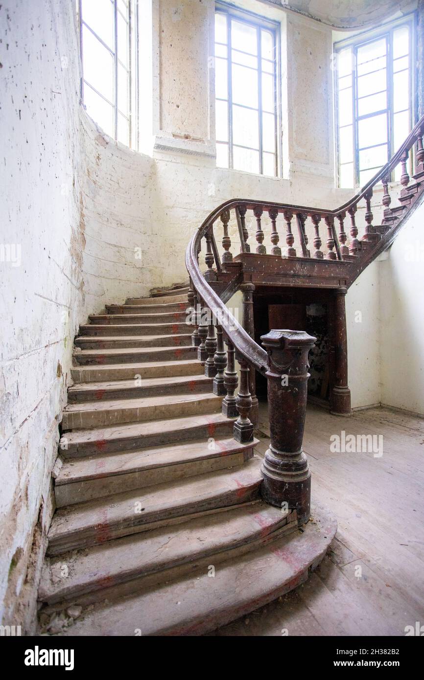 Bottom view of the wooden staircase in an old castle in light colors ...