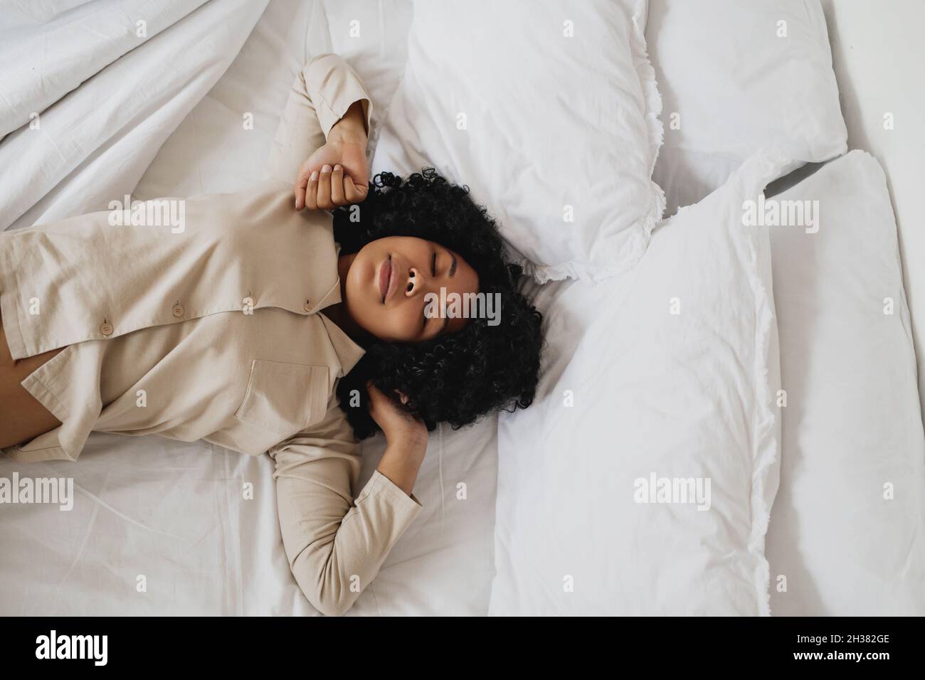 Beautiful African American woman waking up in her bed Stock Photo - Alamy