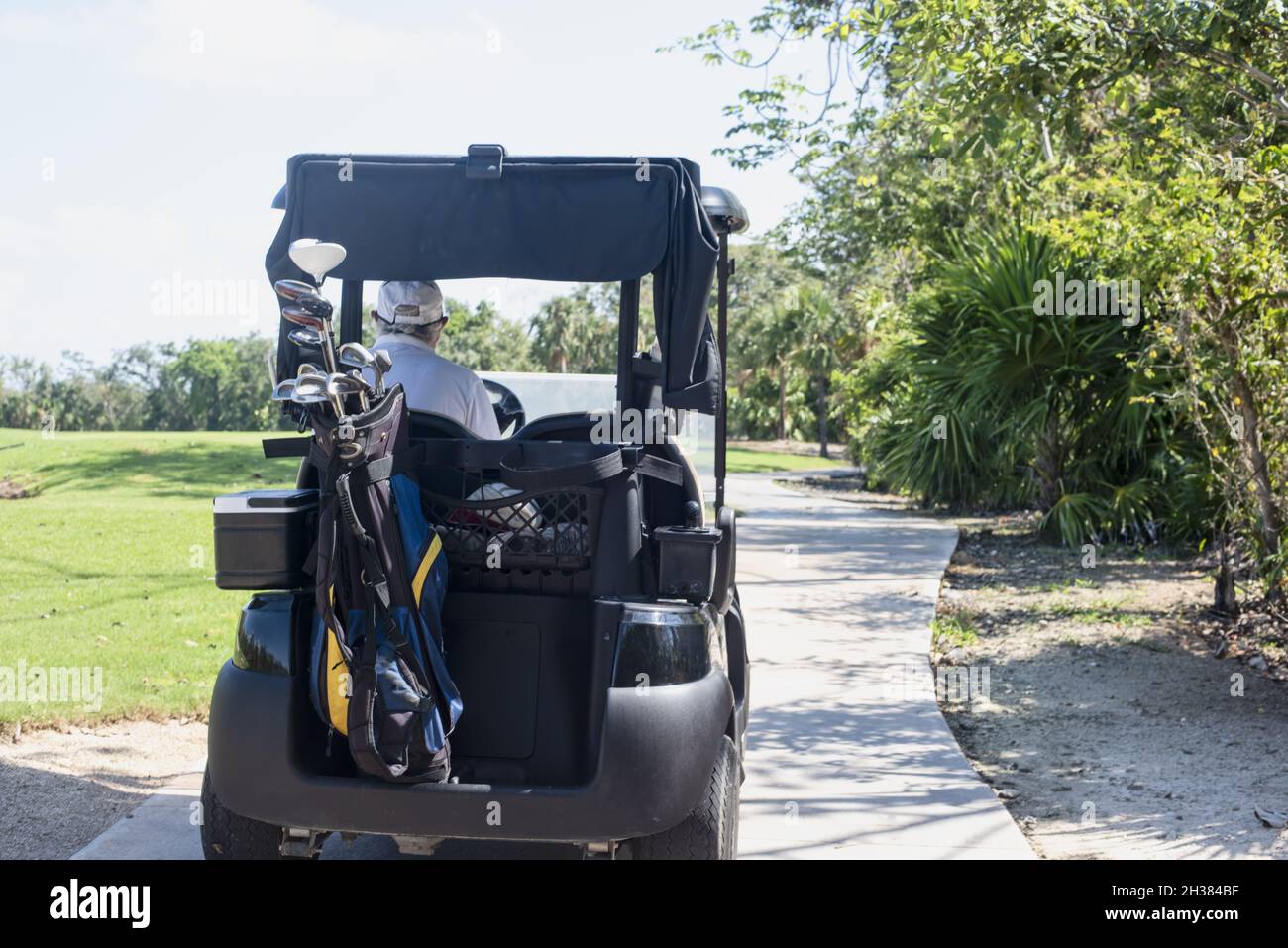 Golfer driving a golf car Stock Photo - Alamy