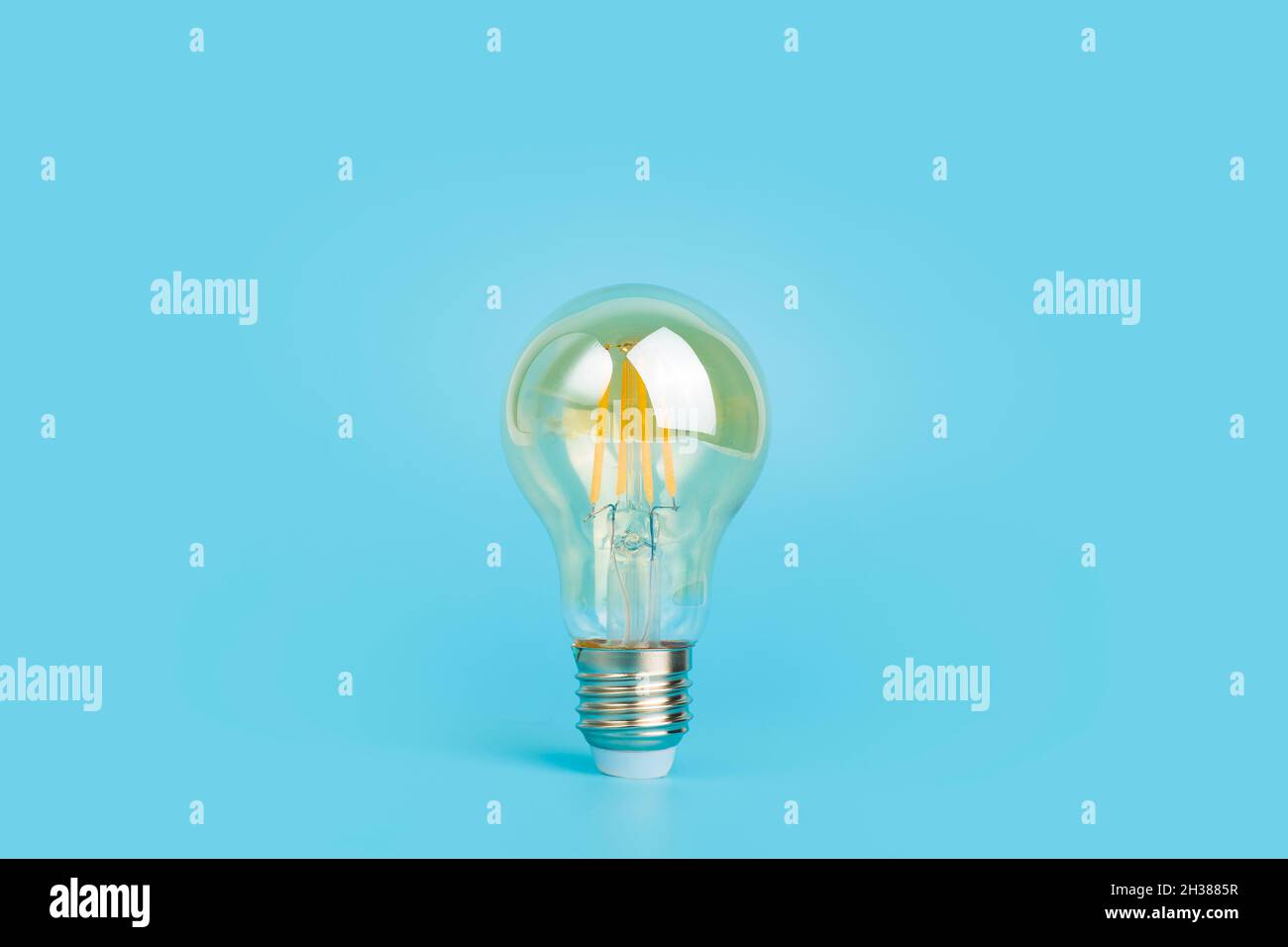 Knowledge and idea concept. Light bulb with light on a blank blue ...