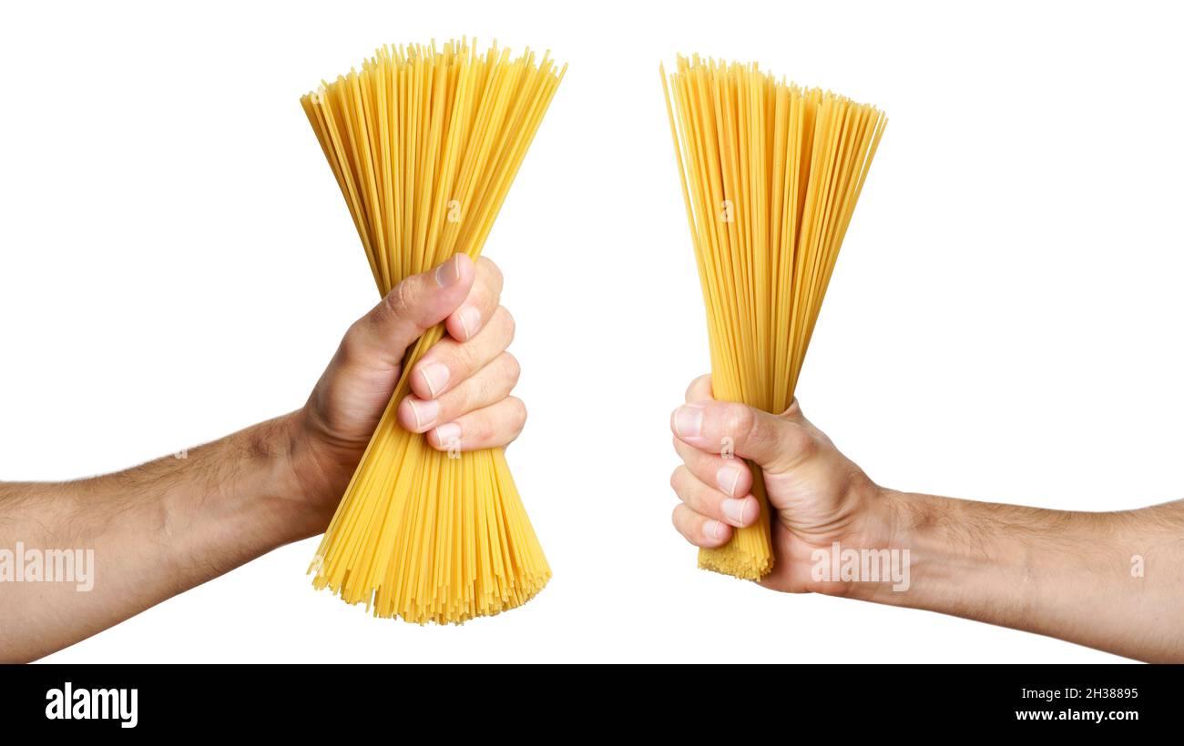 Spaghetti pasta in hand on isolated background. Raw Italian spaghetti ...