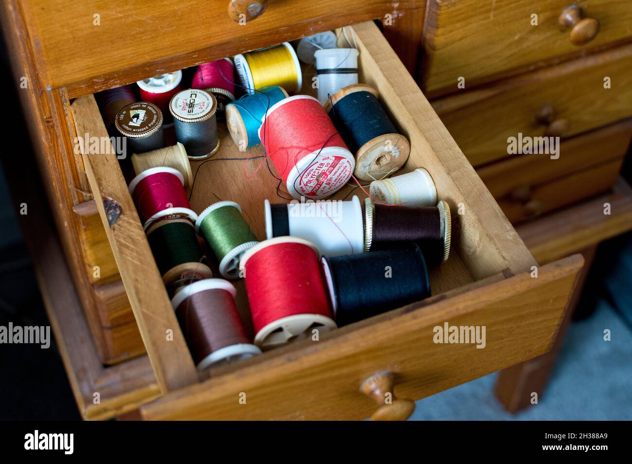 Sewing drawer with spools of thread. Wood sewing cabinet with coloured ...
