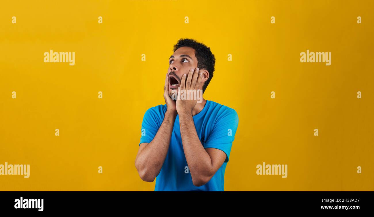 Scared man isolated on yellow background. Handsome Black Man with blue ...