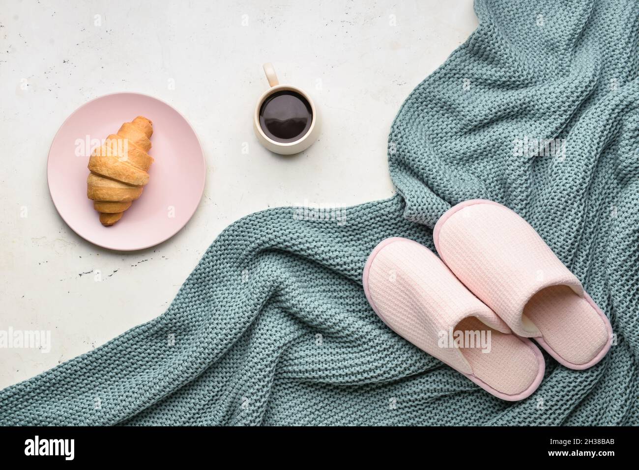 Knitted plaid, breakfast and slippers on white background Stock Photo ...