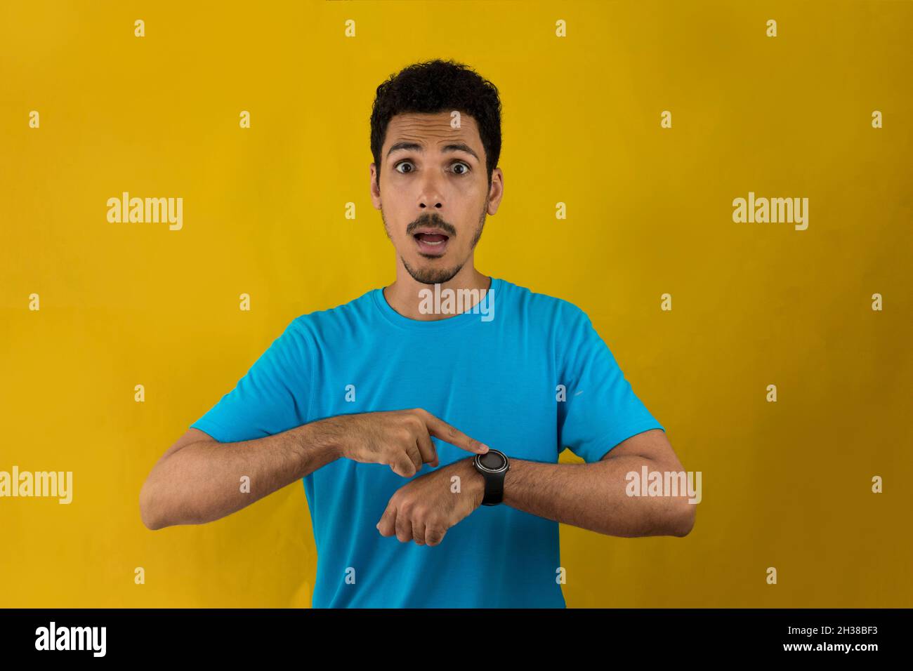 Adult man pointing at his watch on his wrist. Handsome Black Man with ...