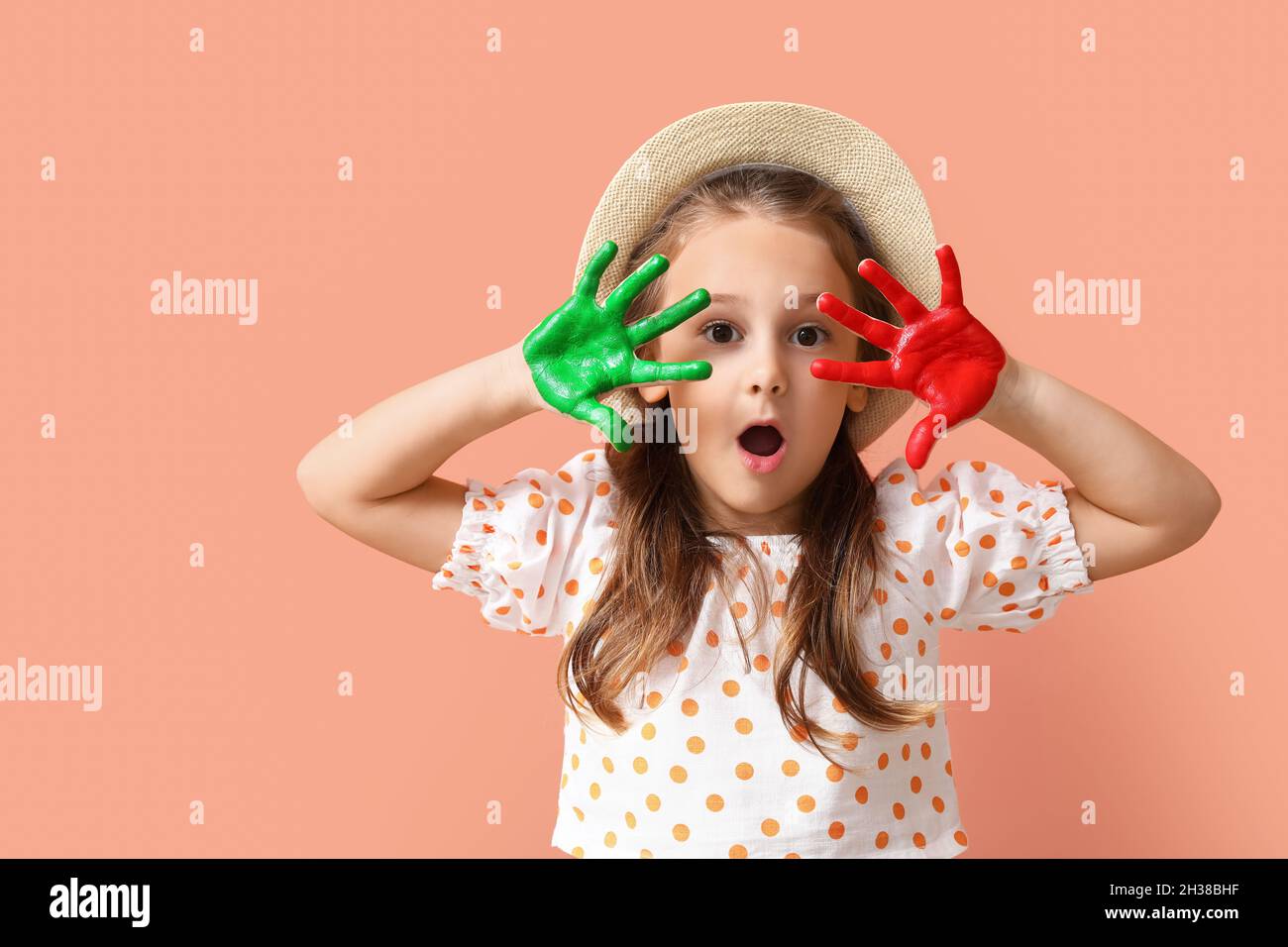 Shocked little girl with palms in paint on pink background Stock Photo - Alamy